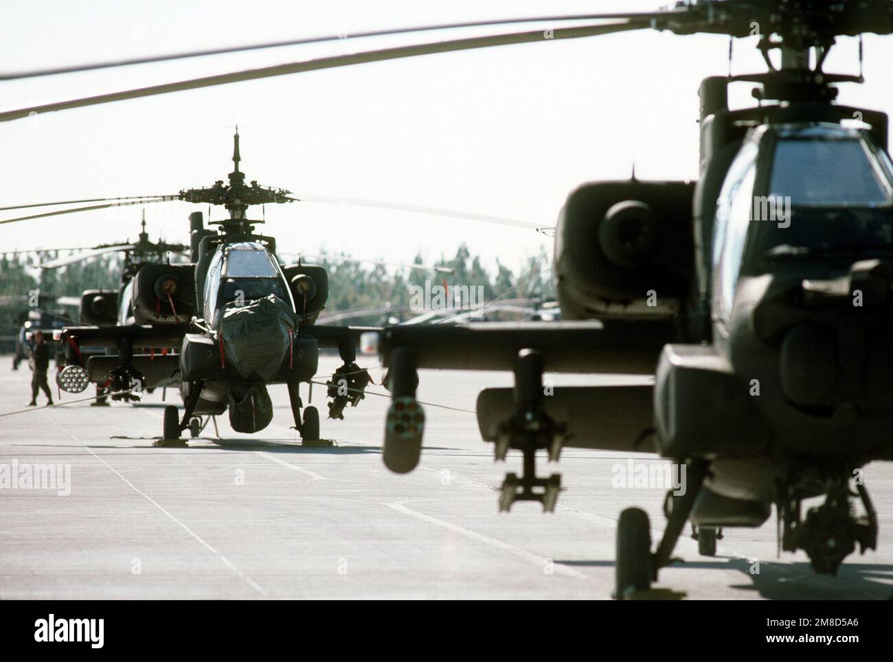 AH-64 Apache helicopters sit parked on the flight line. Base: Simmons ...
