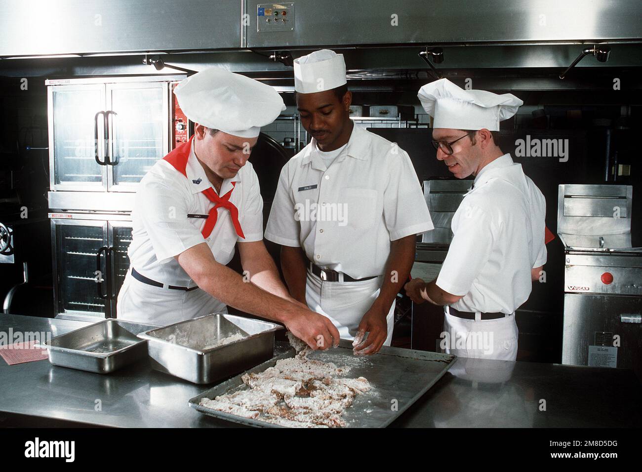 Basic AIRMAN Kevin Scales, center, learns to batter chicken-fried steak ...