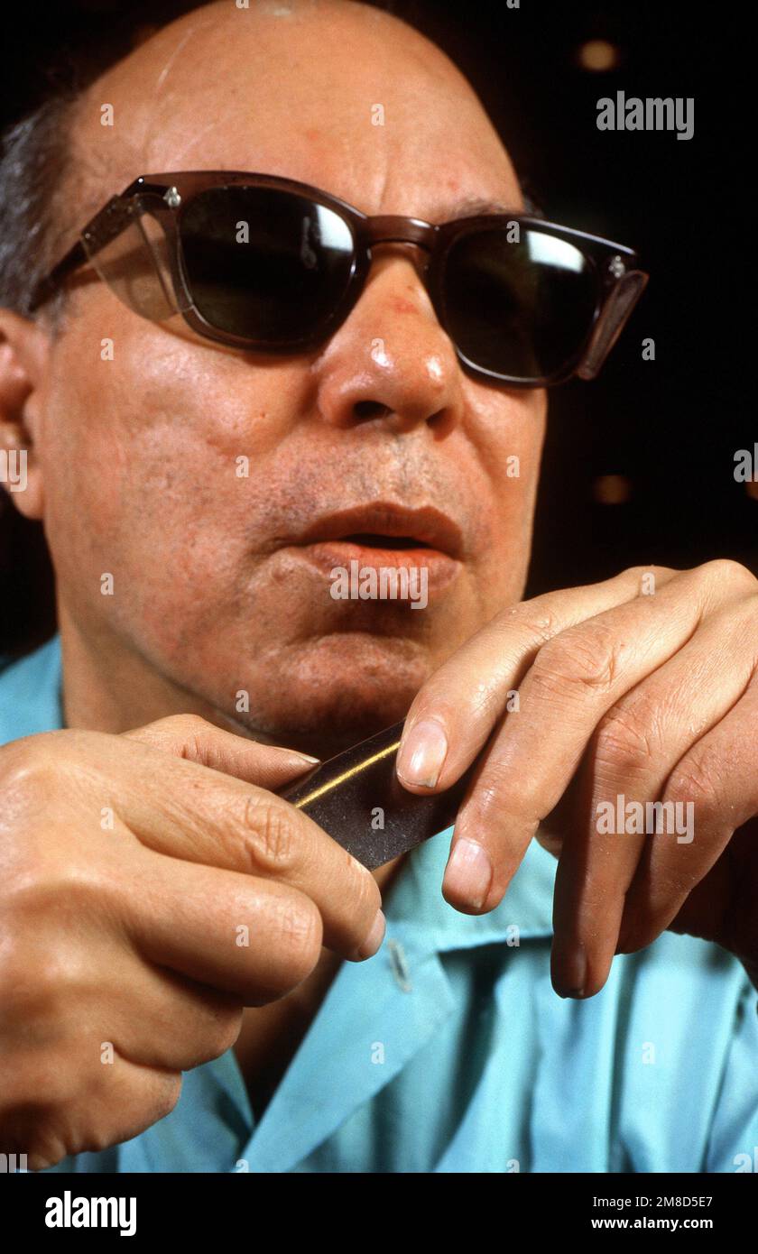 Joe Gonzales uses his fingers to inspect a turbine blade for an F-15 ...