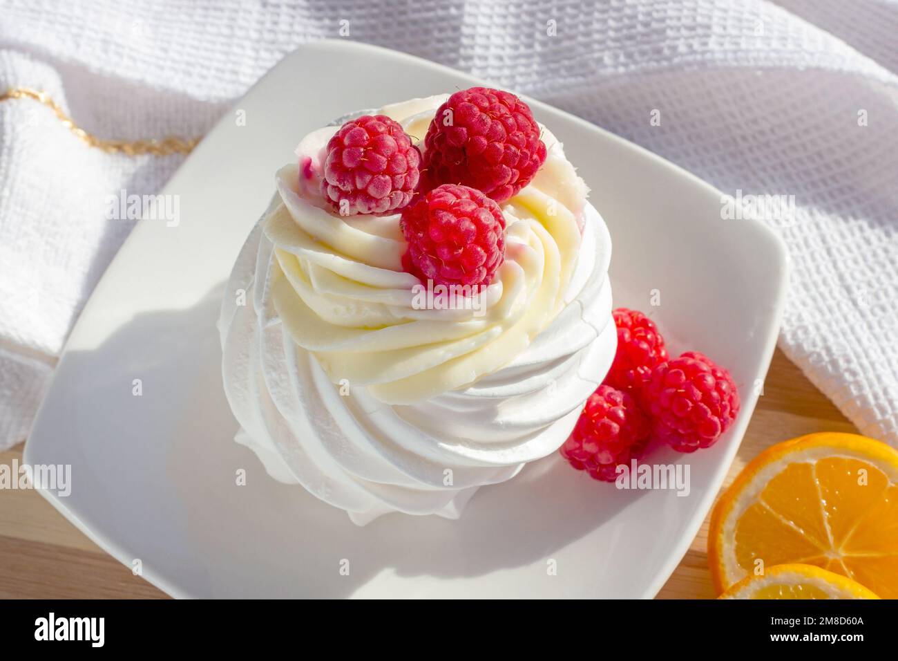 White mini meringue Pavlova cake with sweet pink raspberry berries and ...