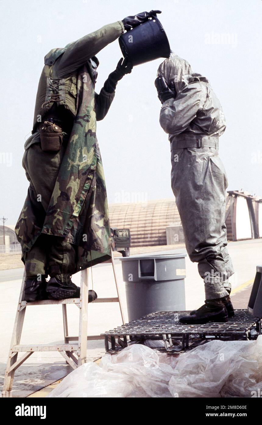 A South Korean soldier covers the filters on his gas mask as another ...