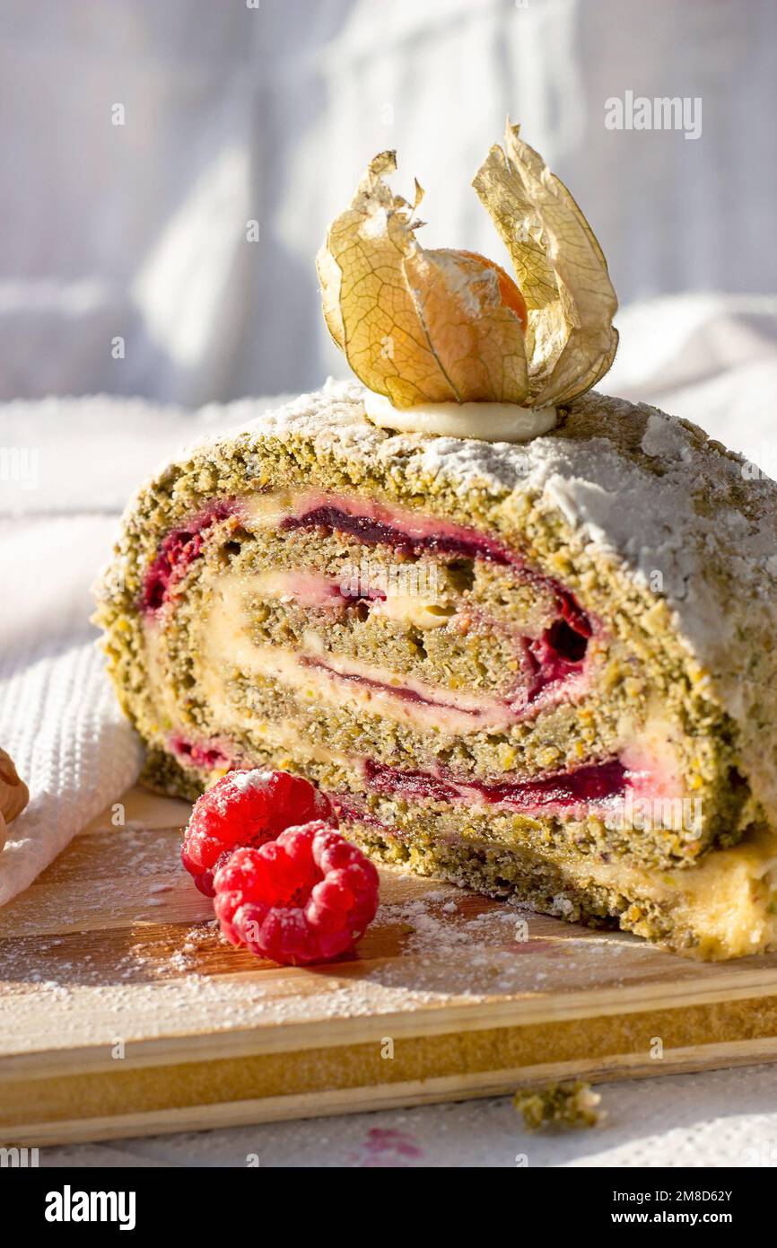 Green pistachio meringue roulade slice with raspberry jelly jam on ...