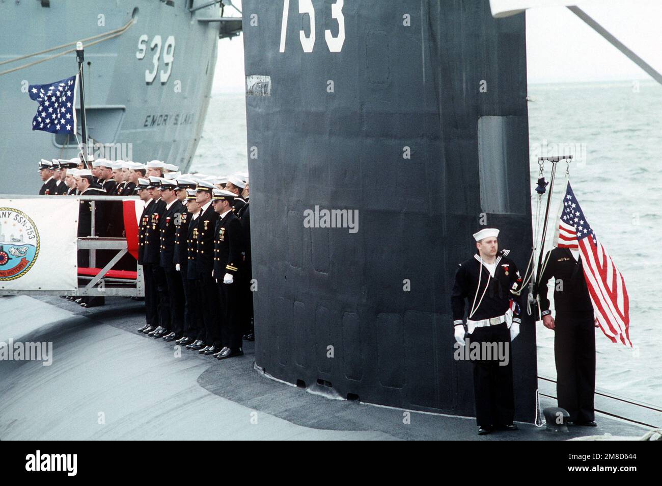 Officers and crew members stand at attention as the commissioning ...