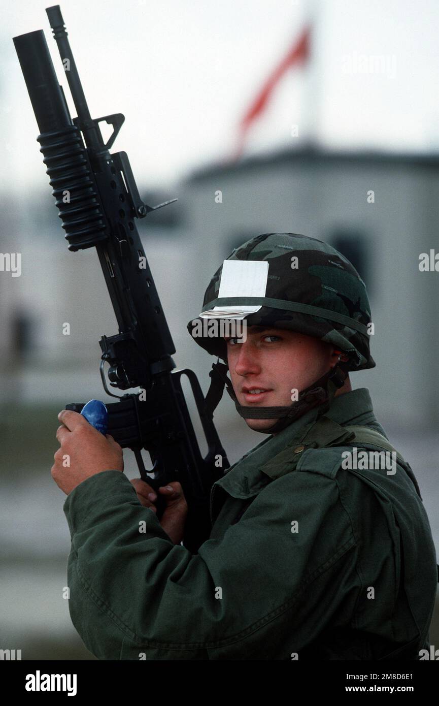 AMN Gene Culbert raises an M-16A2 rifle equipped with an M-203 grenade ...