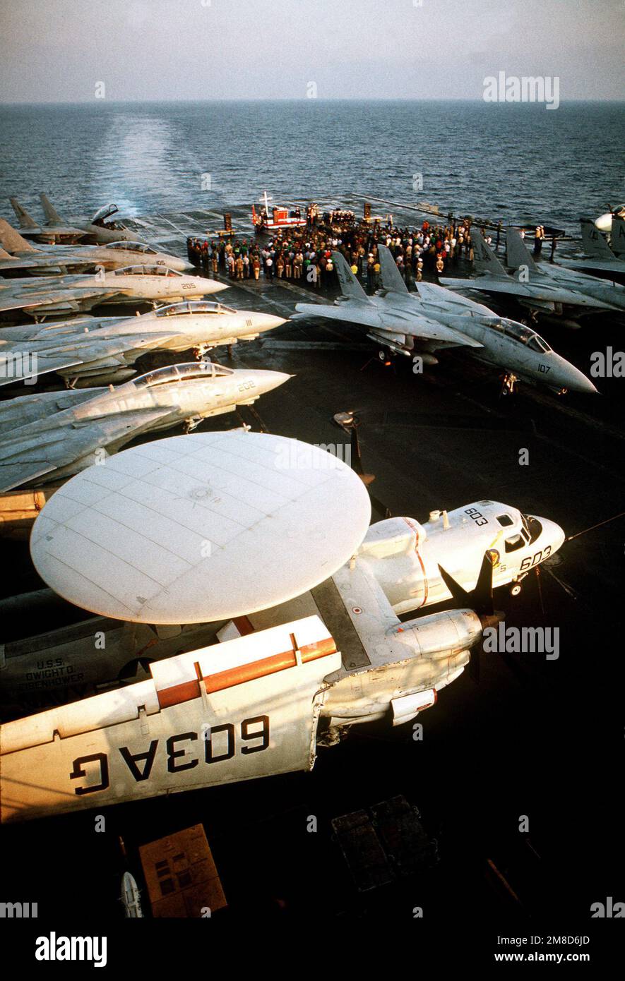 Surrounded by a group of F-14A Tomcat aircraft and an E-2C Hawkeye ...