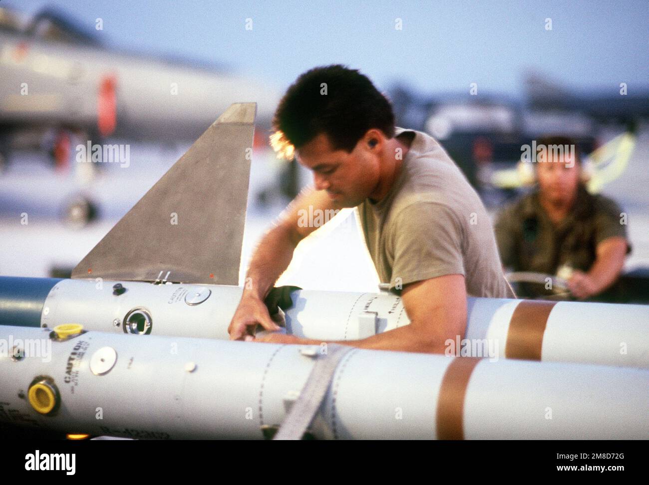 AIM-7 Sparrow missiles are prepared on the flight line for loading on F ...