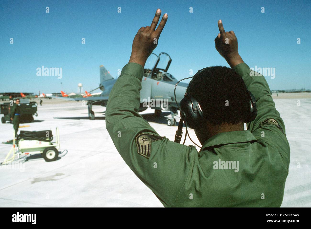 A ground crew member signals to the pilot of a 37th Tactical Fighter ...