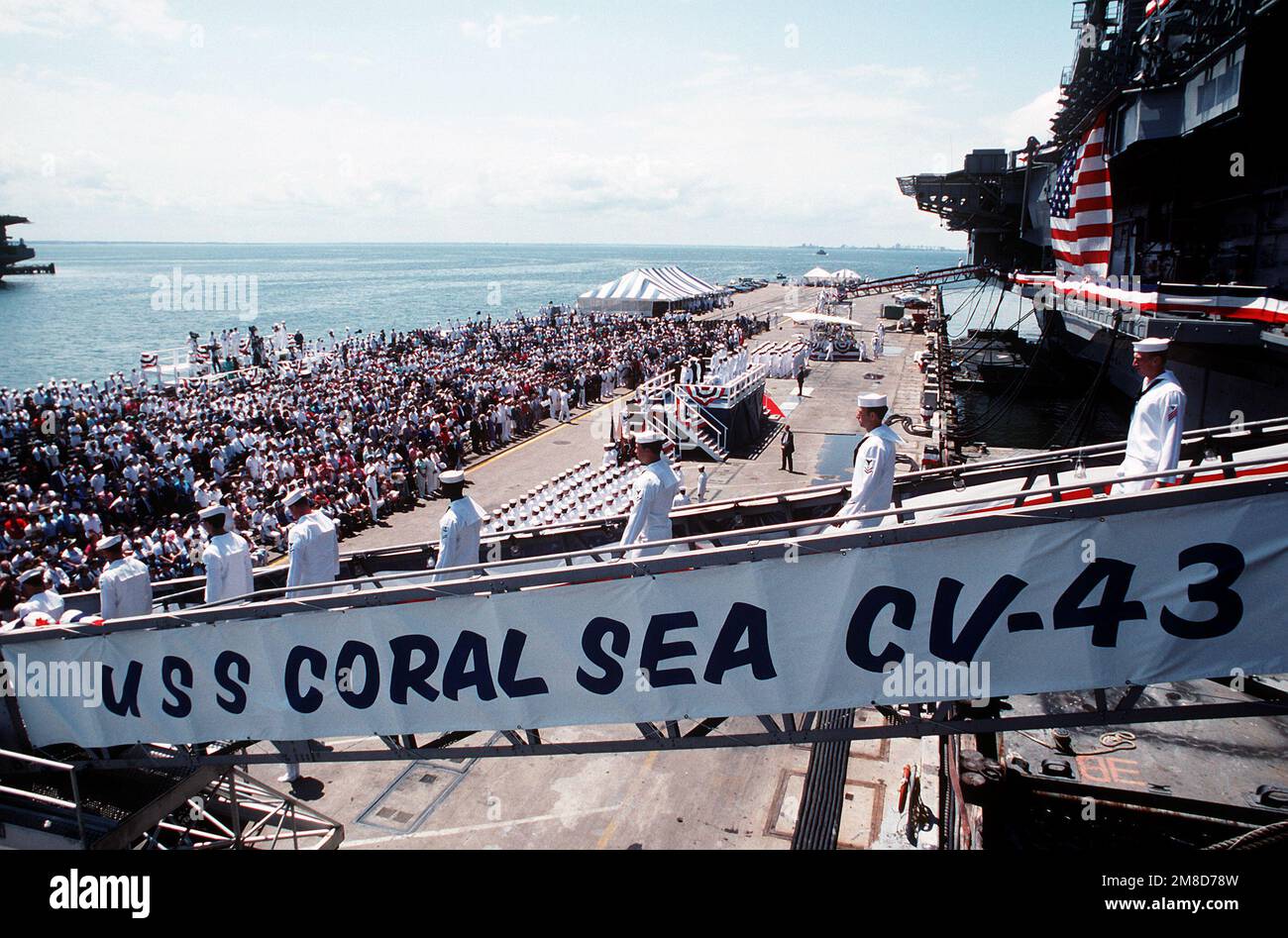 Crew members file down the gangway during the decommissioning ceremony ...