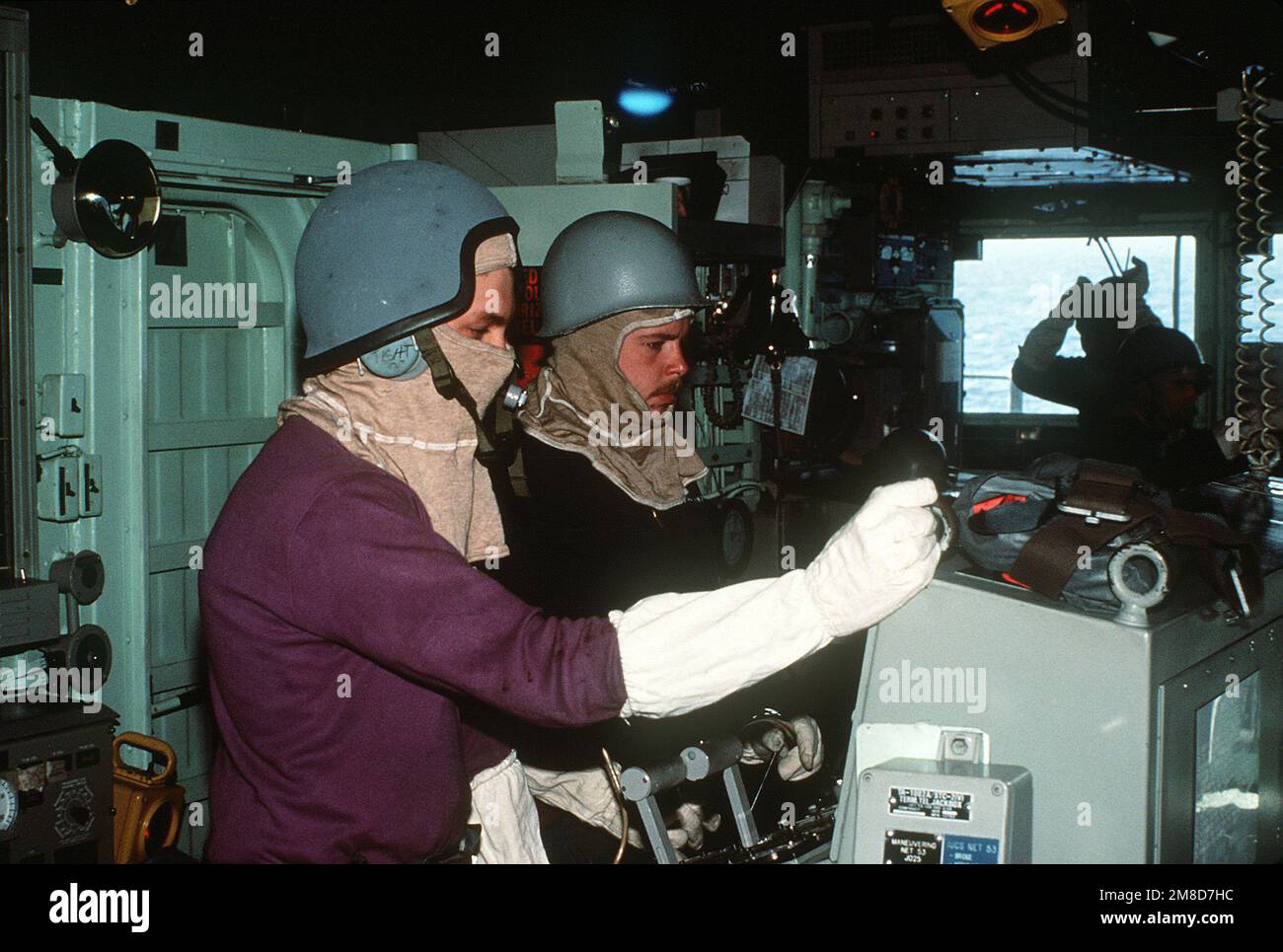 Sailors on the bridge of a U.S. Navy ship wear helmets and flash gear ...
