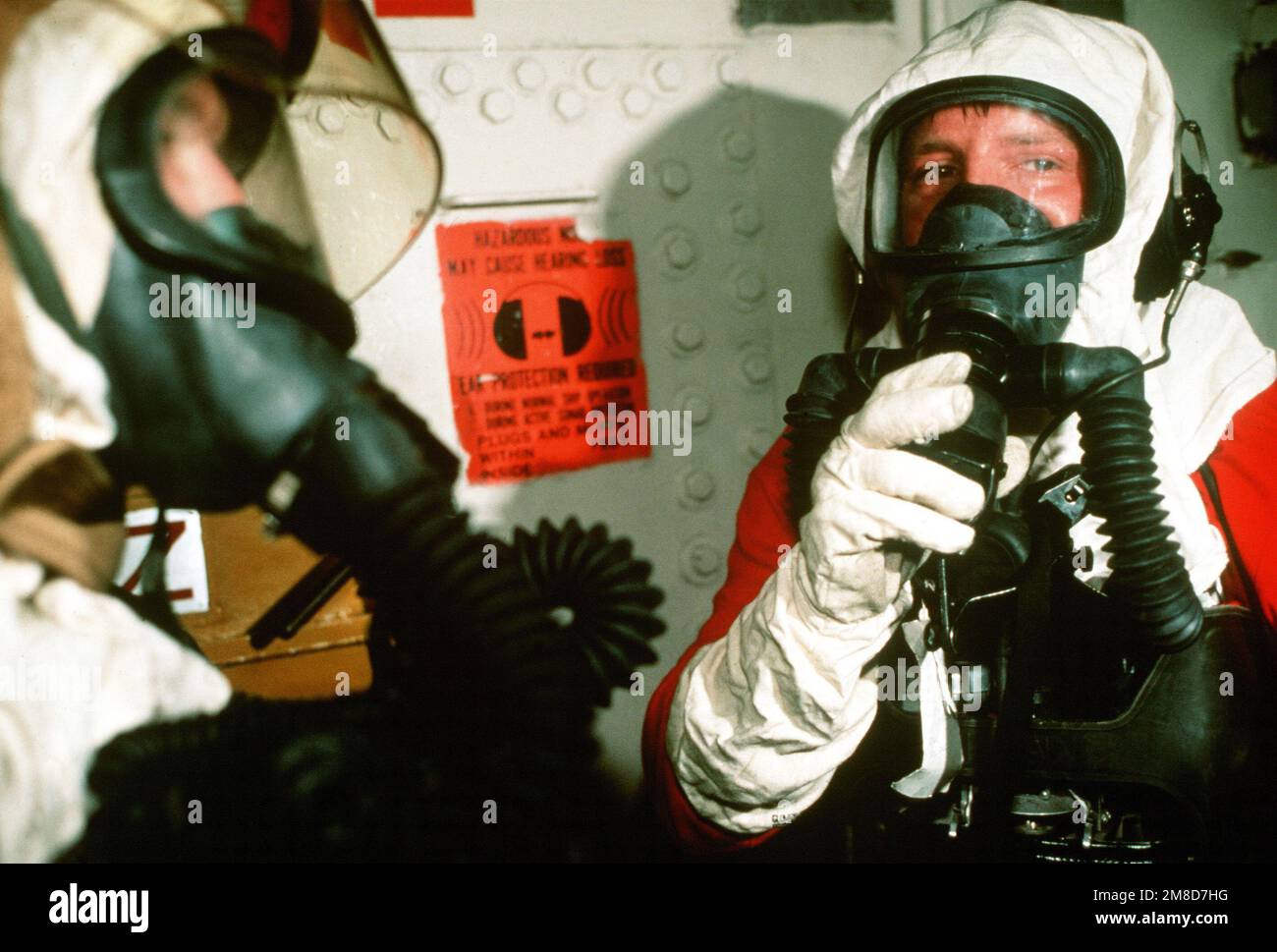 Two sailors aboard a U.S. Navy ship wear oxygen breathing apparatuses ...