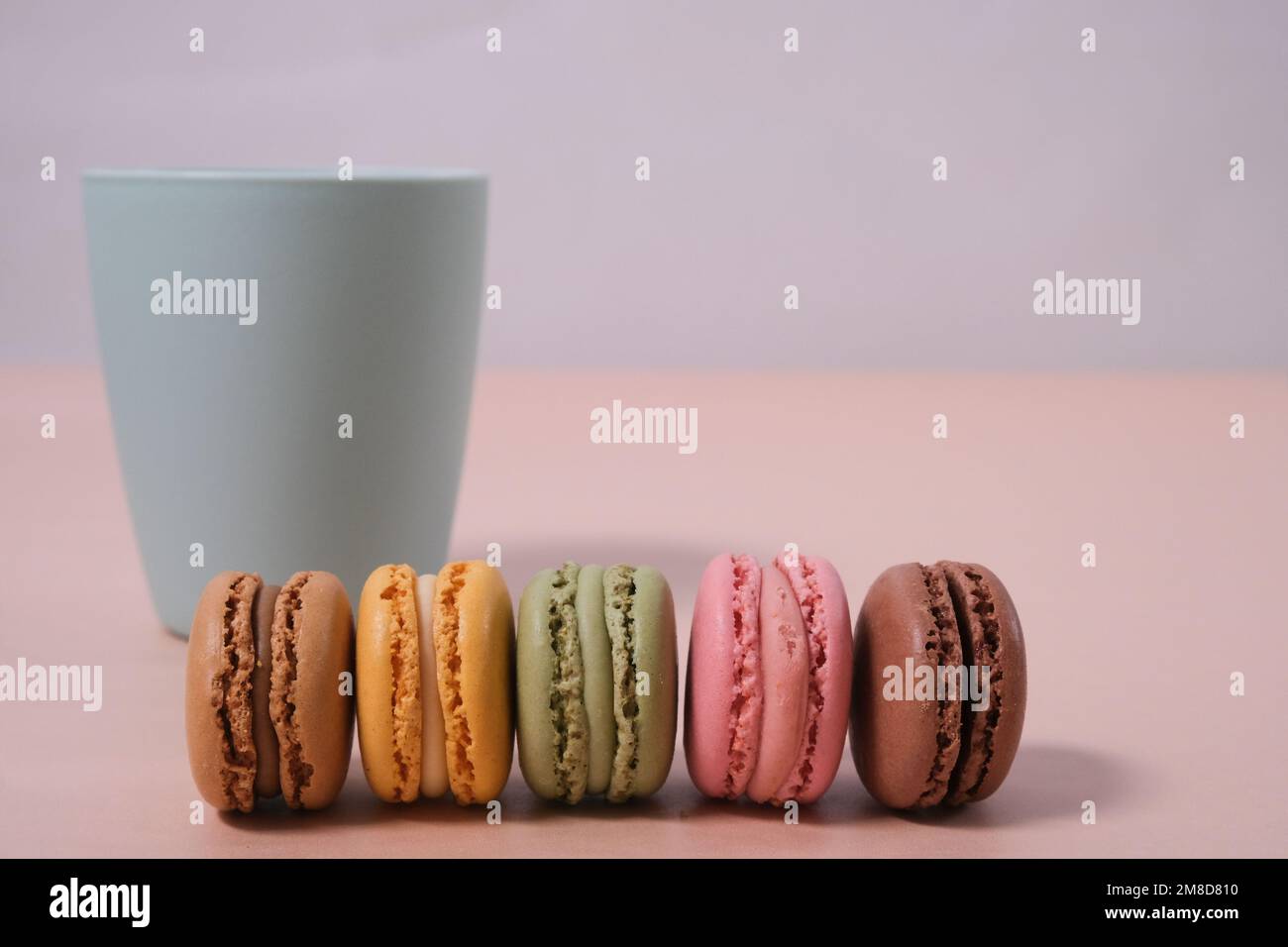 macarons of different colors and flavors on a background with pastel ...
