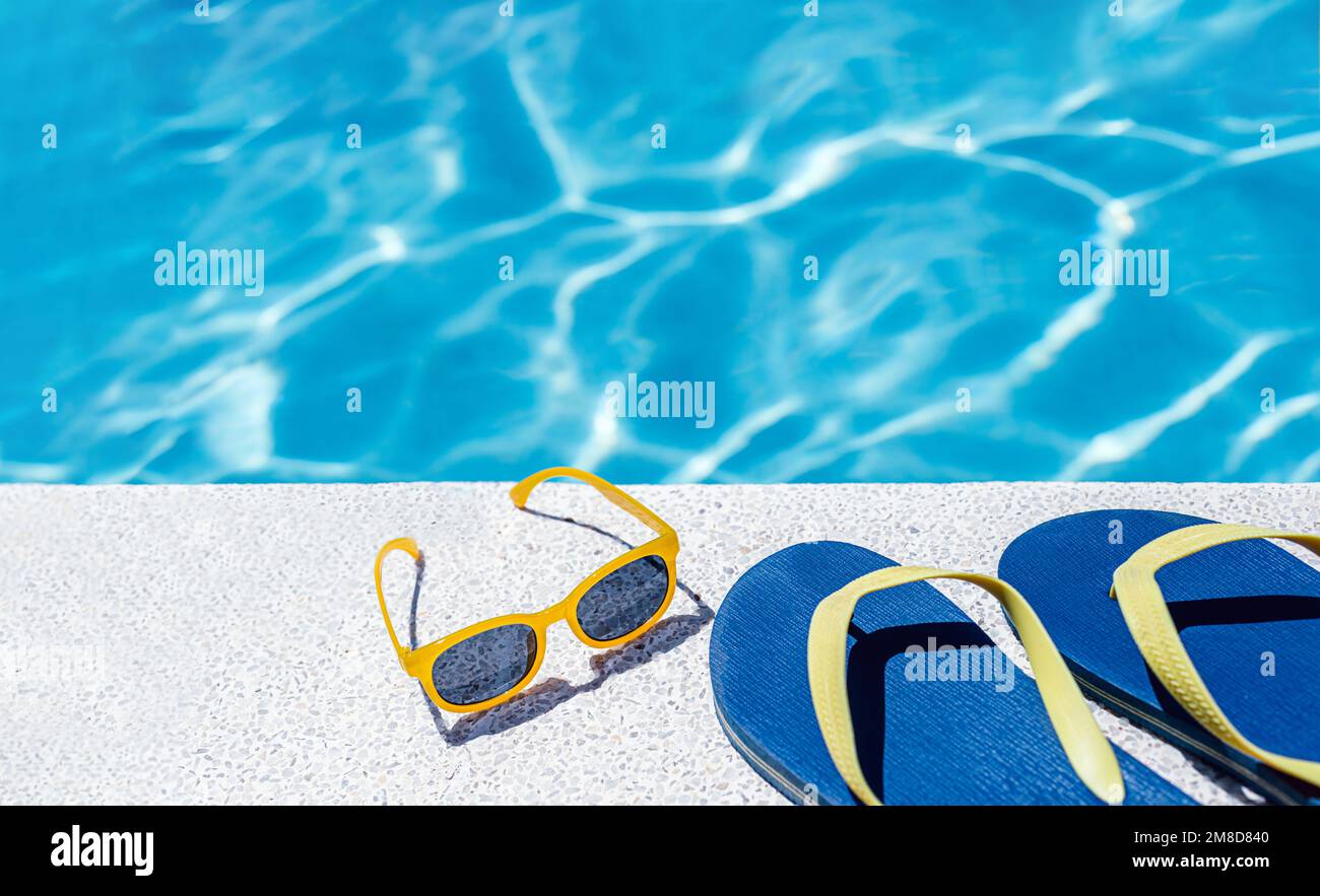back view of flip flops and goggles on the white border of a swimming ...