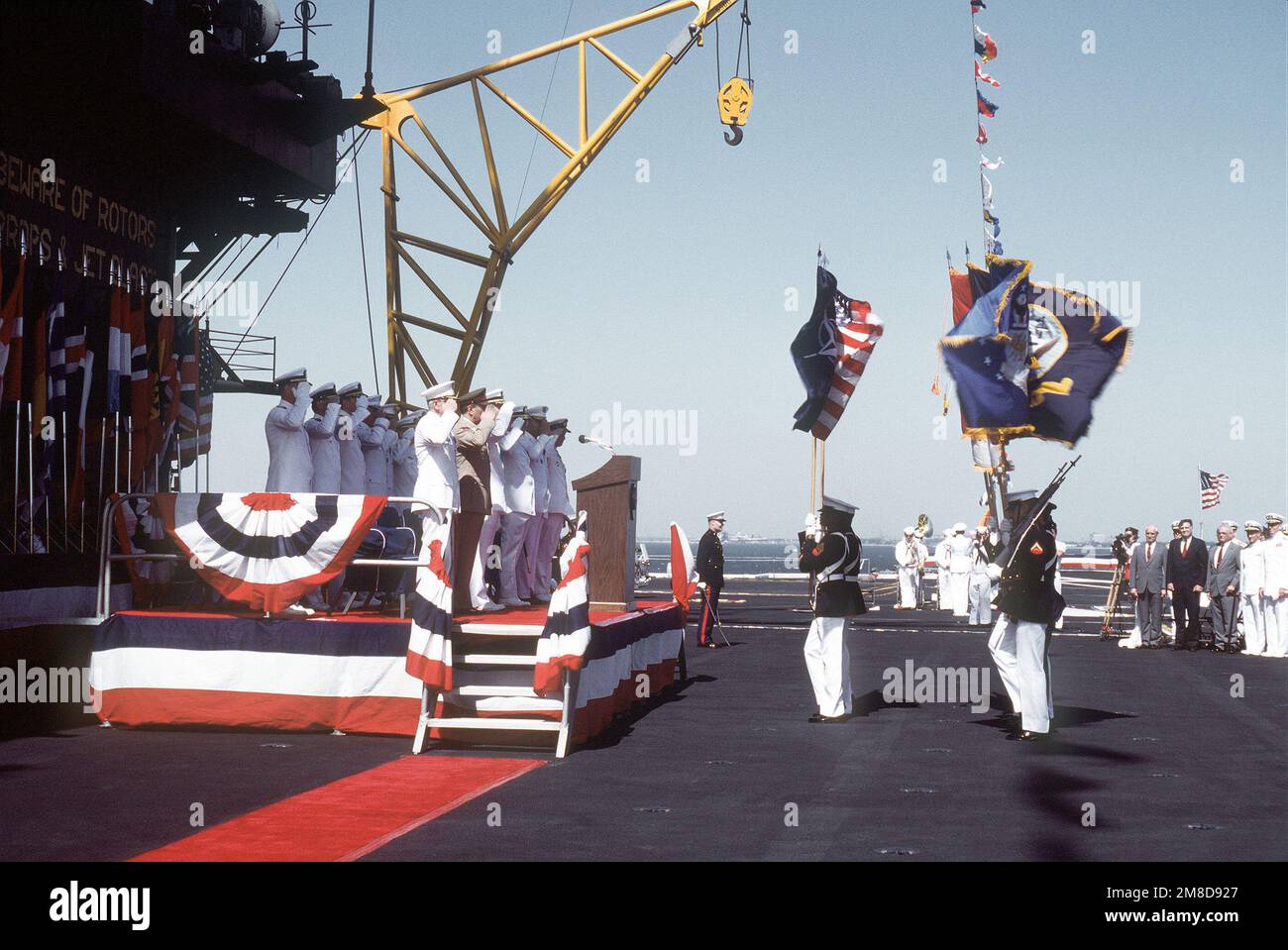 Flag officers salute as the colors are presented during the change of ...