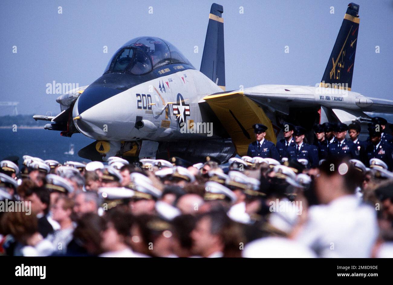 Guests stand in a crowd beside an F-14A Tomcat aircraft of Fighter ...