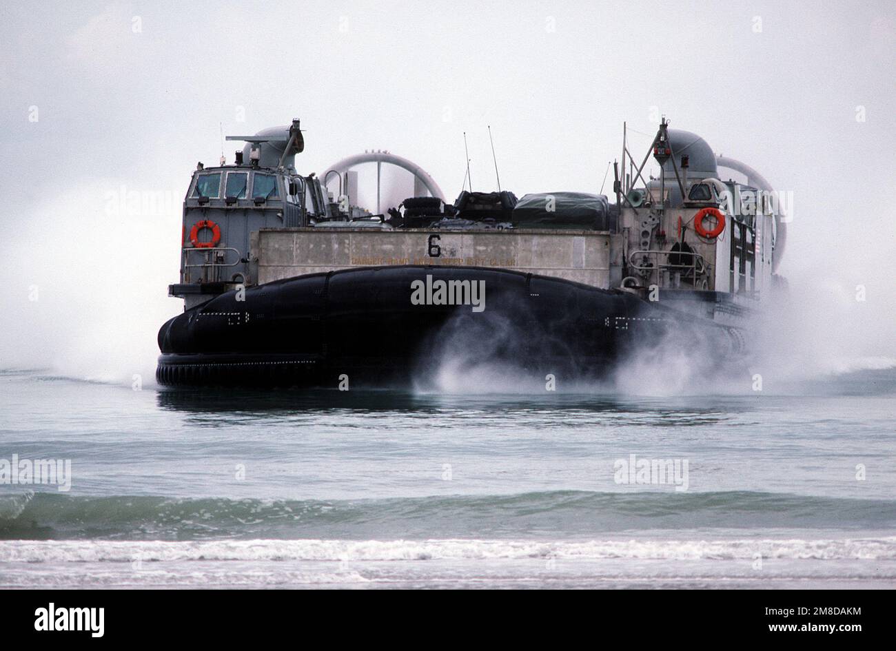 The air cushion landing craft LCAC-6 comes ashore with a load of vehicles during the combined ...