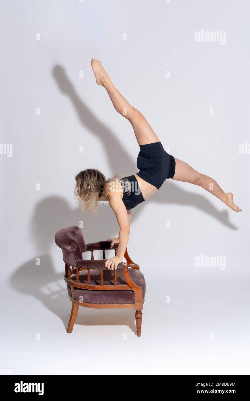 A vertical shot of a Young Caucasian dancer in the studio performing a ...