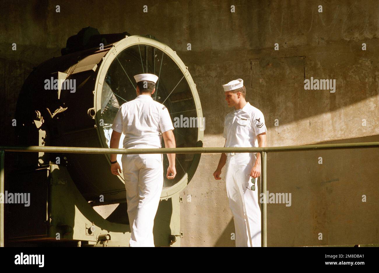 US Navy sailors admire a searchlight from a World War II ship. The ...