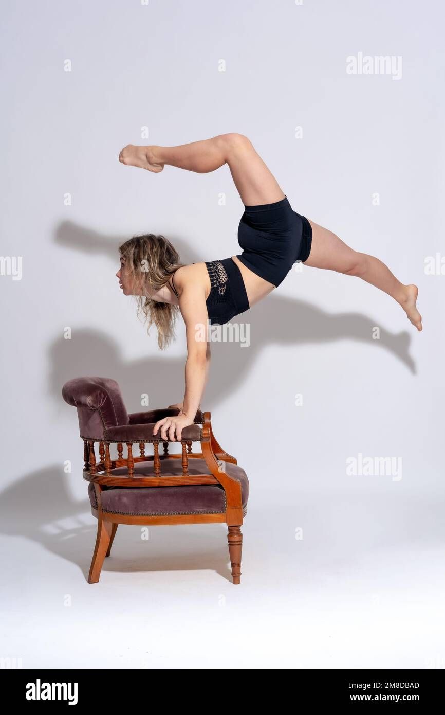 A vertical shot of a Young Caucasian dancer in the studio performing a ...