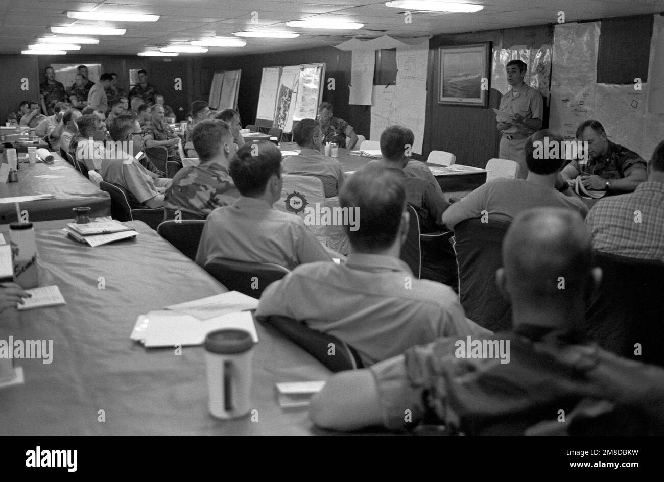 Navy and Marine officers receive an operational status briefing in the ...