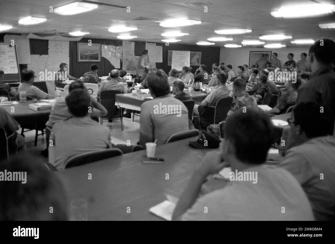 Navy and Marine officers receive an operational status briefing in the ...
