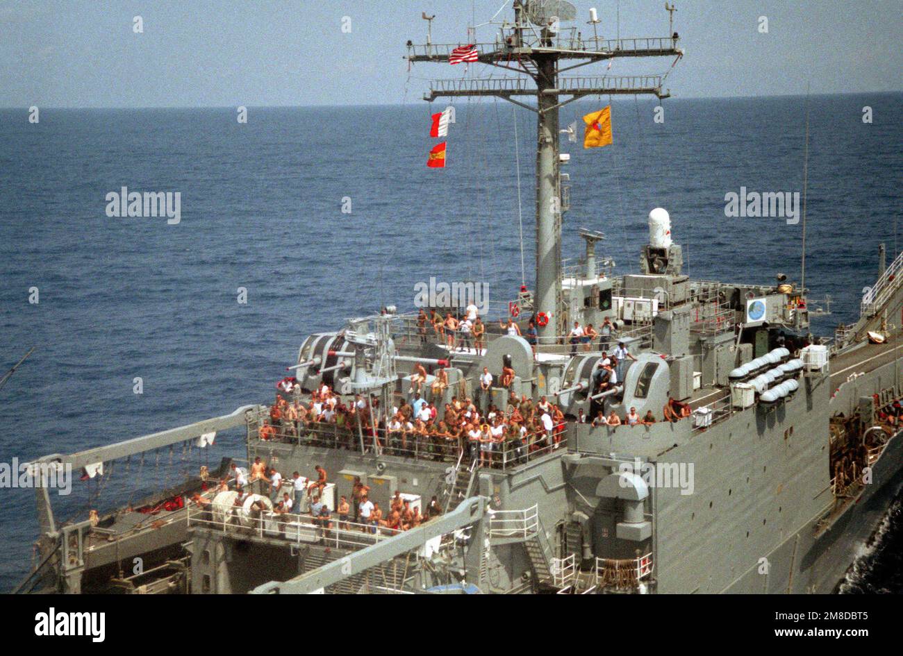 Off-duty sailors and Marines congregate on the weather decks aboard the ...