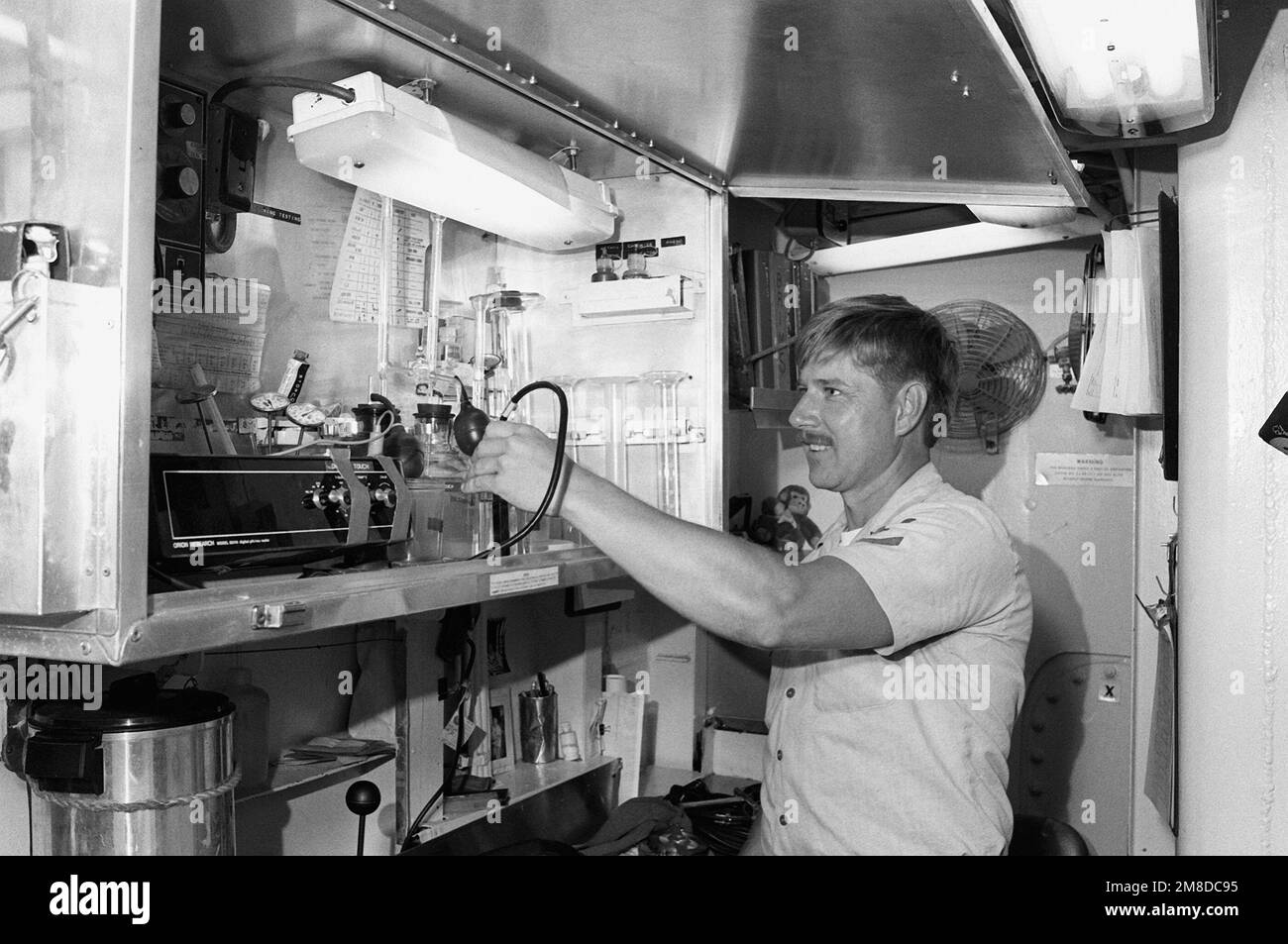 Boiler Technician 3rd Class (BT3) Jeff Truett checks an oil sample ...