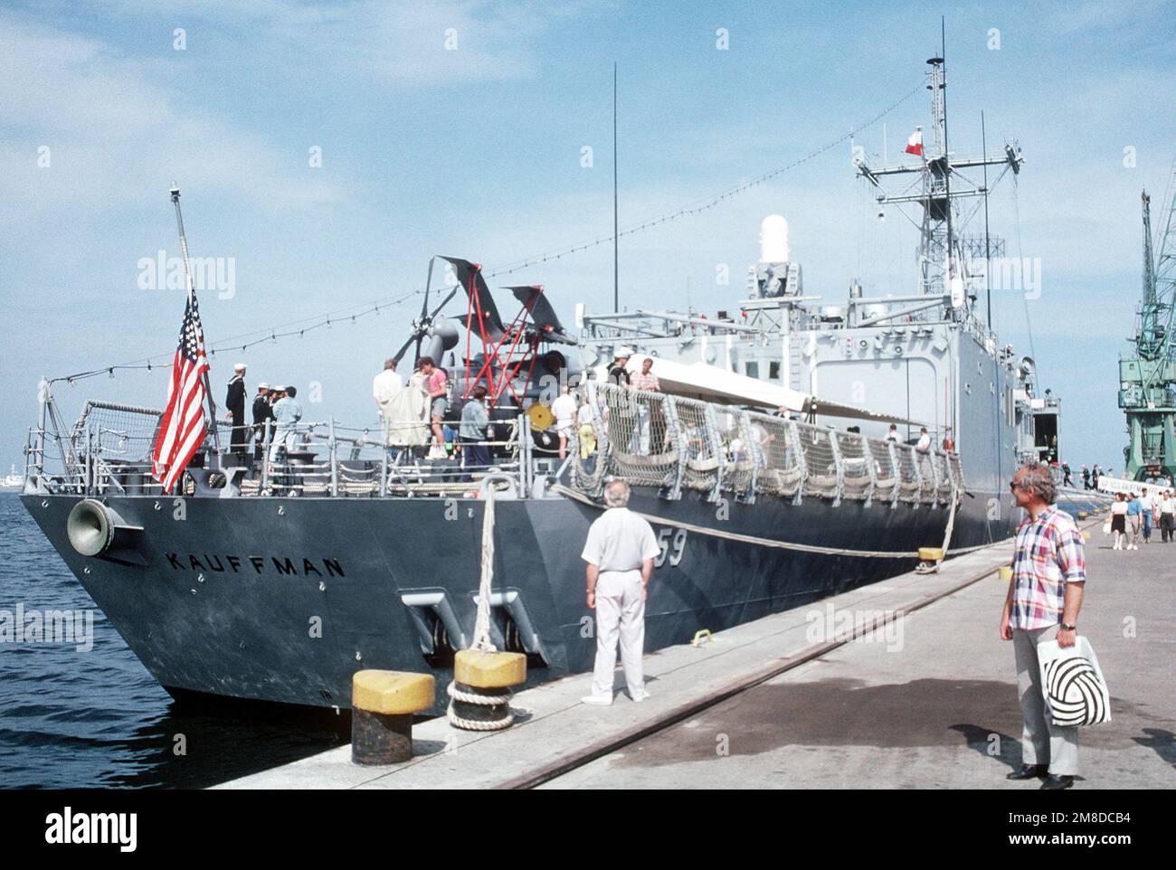 Passersby stop to look at the guided missile frigate USS KAUFFMAN (FFG ...