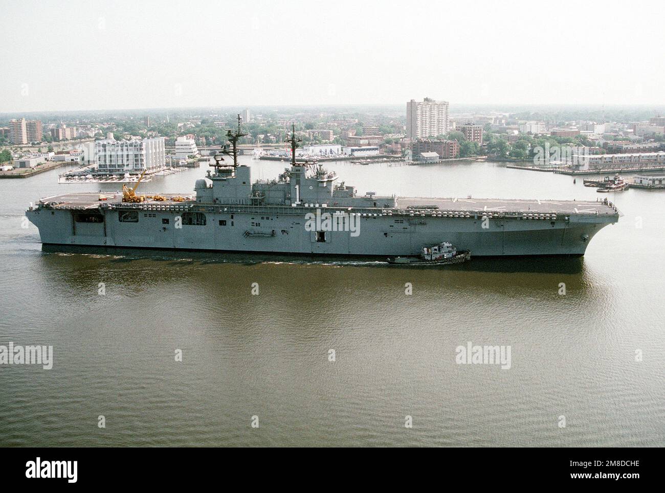 A large harbor tug maneuvers the amphibious assault ship USS WASP (LHD ...