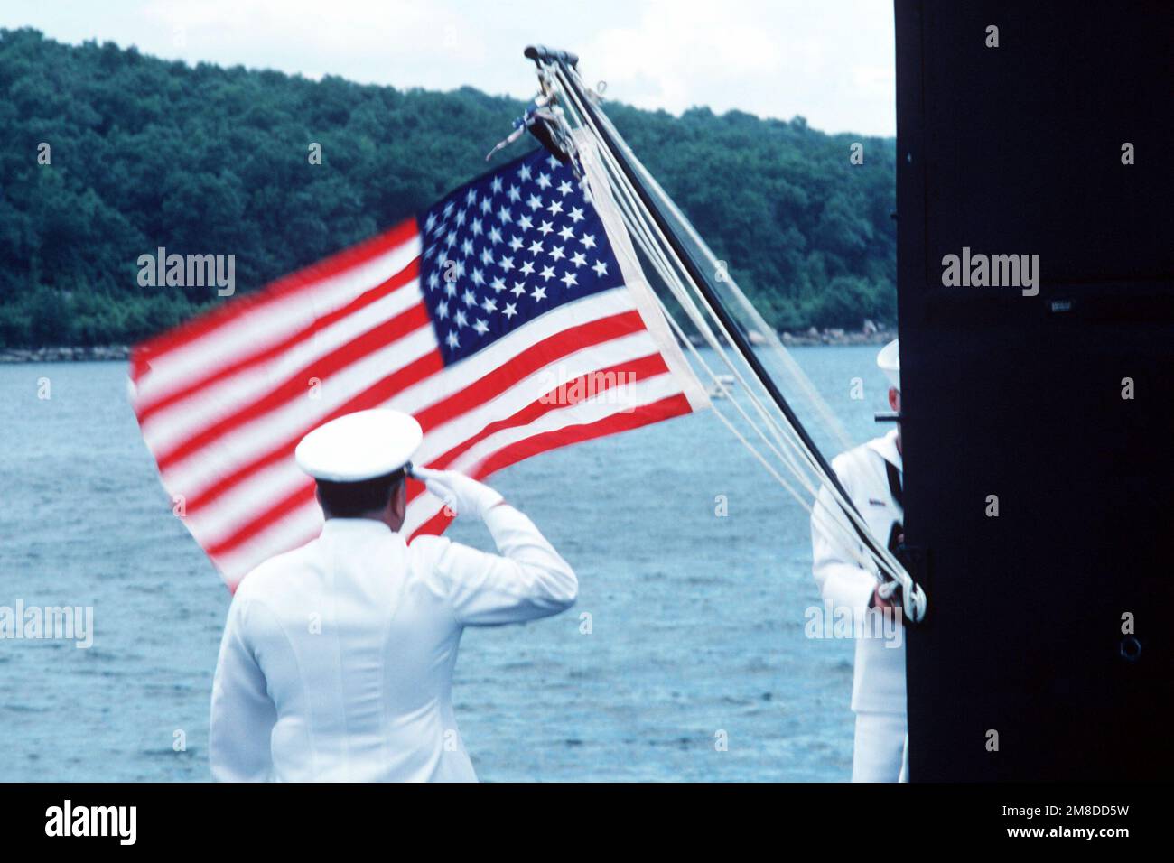 The chief petty officer salutes the American flag aboard the nuclear ...