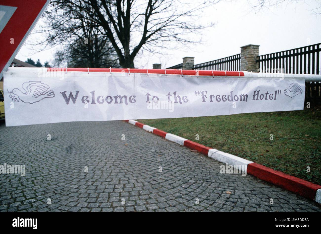A sign welcoming refugees from East Germany decorates the front gate of ...