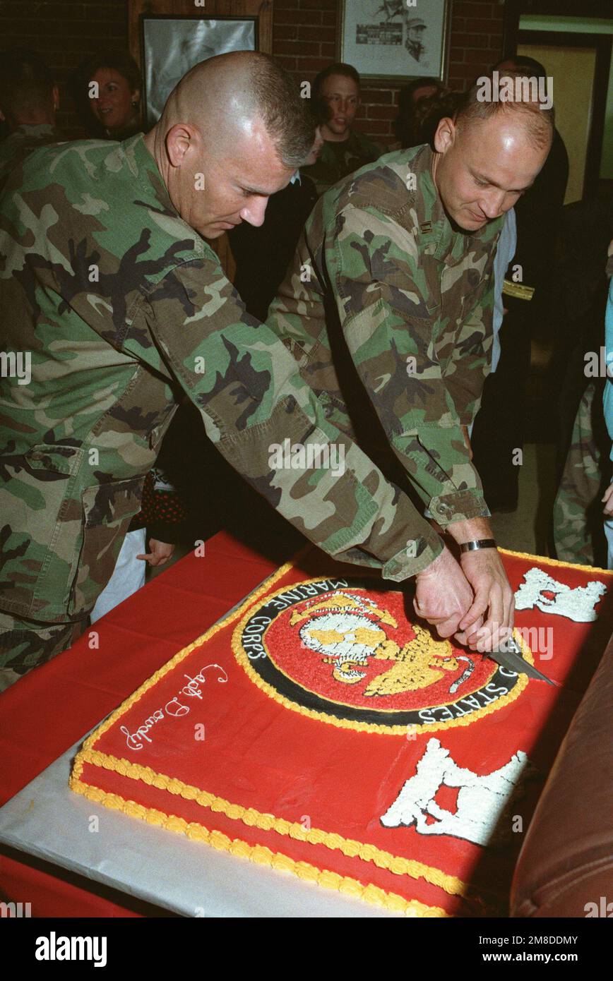 MAJ Peter Kopf, left, and CPT Joe Dowdy cut a cake at a reception ...