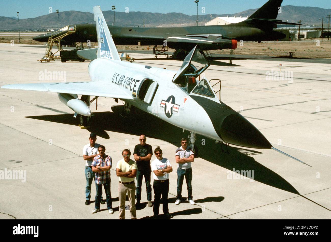 Rockwell International maintenance personnel stand in front of an F ...