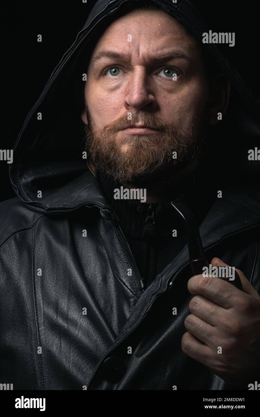 Portrait of a Bearded man in Black Rain Jacket Smoking a Pipe Stock ...