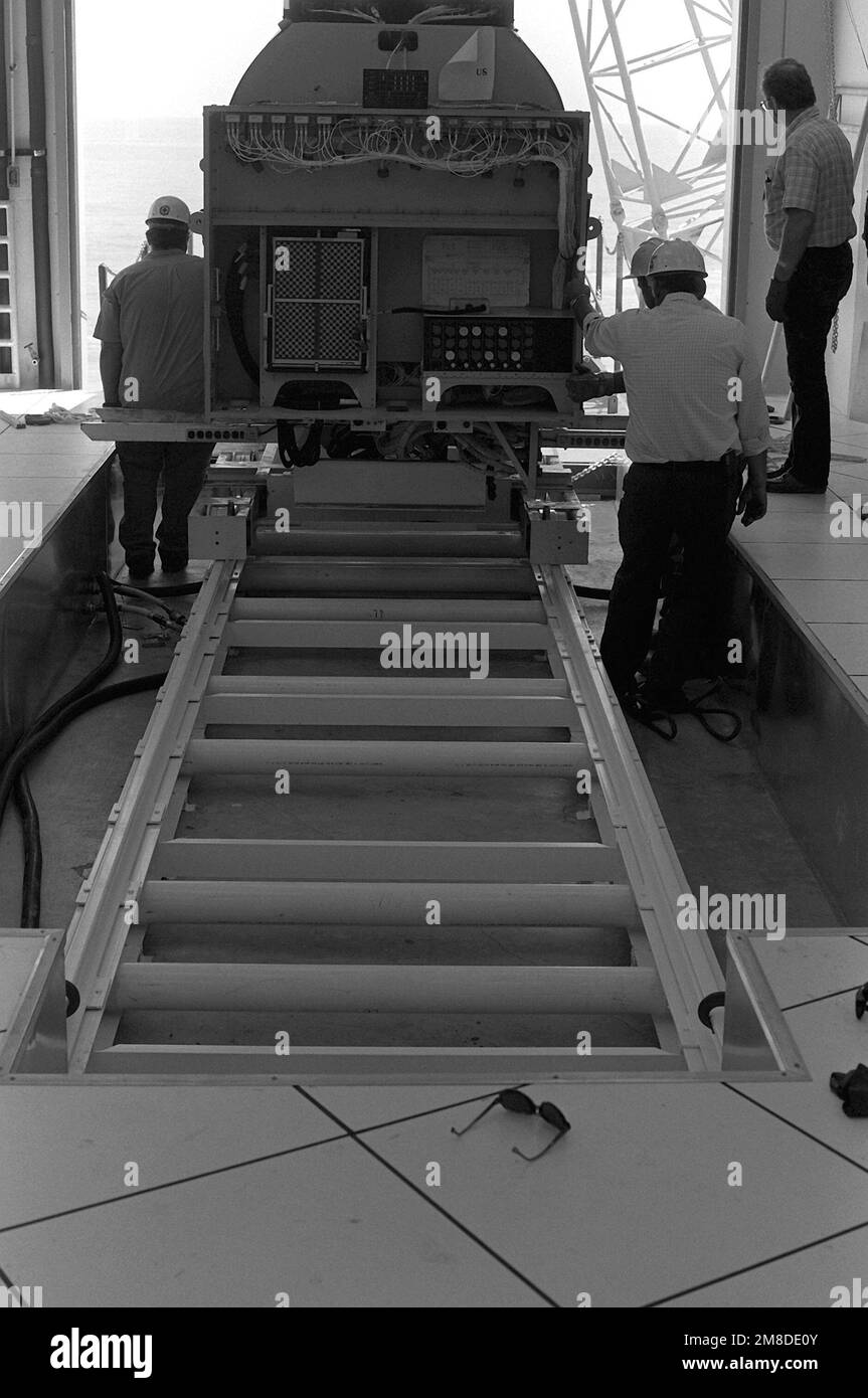 Workers guide an F-14D Tomcat aircraft engineering and manufacturing ...