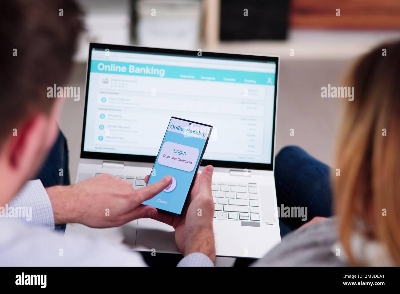 Couple Checking Bank Account Online On Couch Stock Photo - Alamy