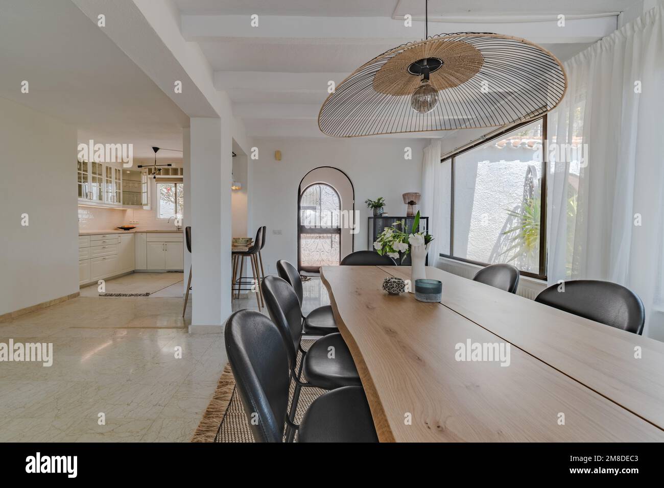 long wooden dining table with open kitchen in the background Stock ...