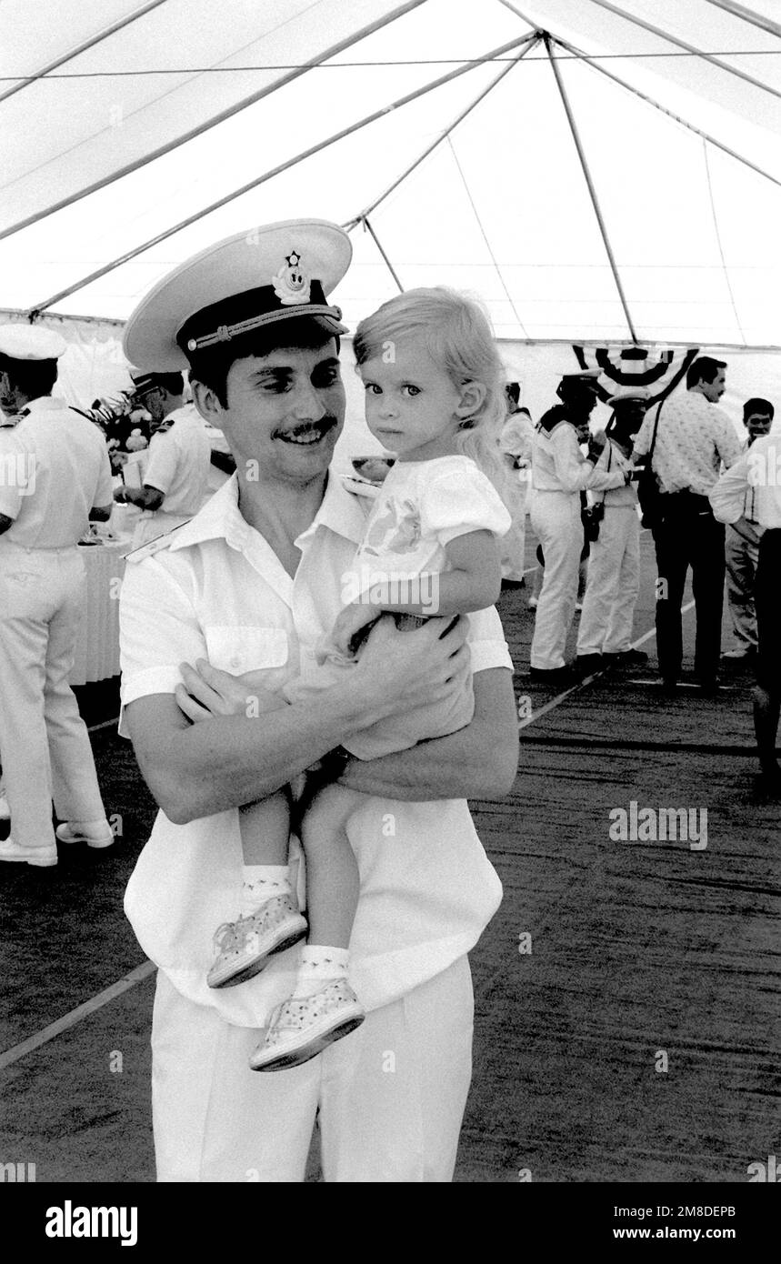 A Soviet navy senior lieutenant holds an American officer's child ...