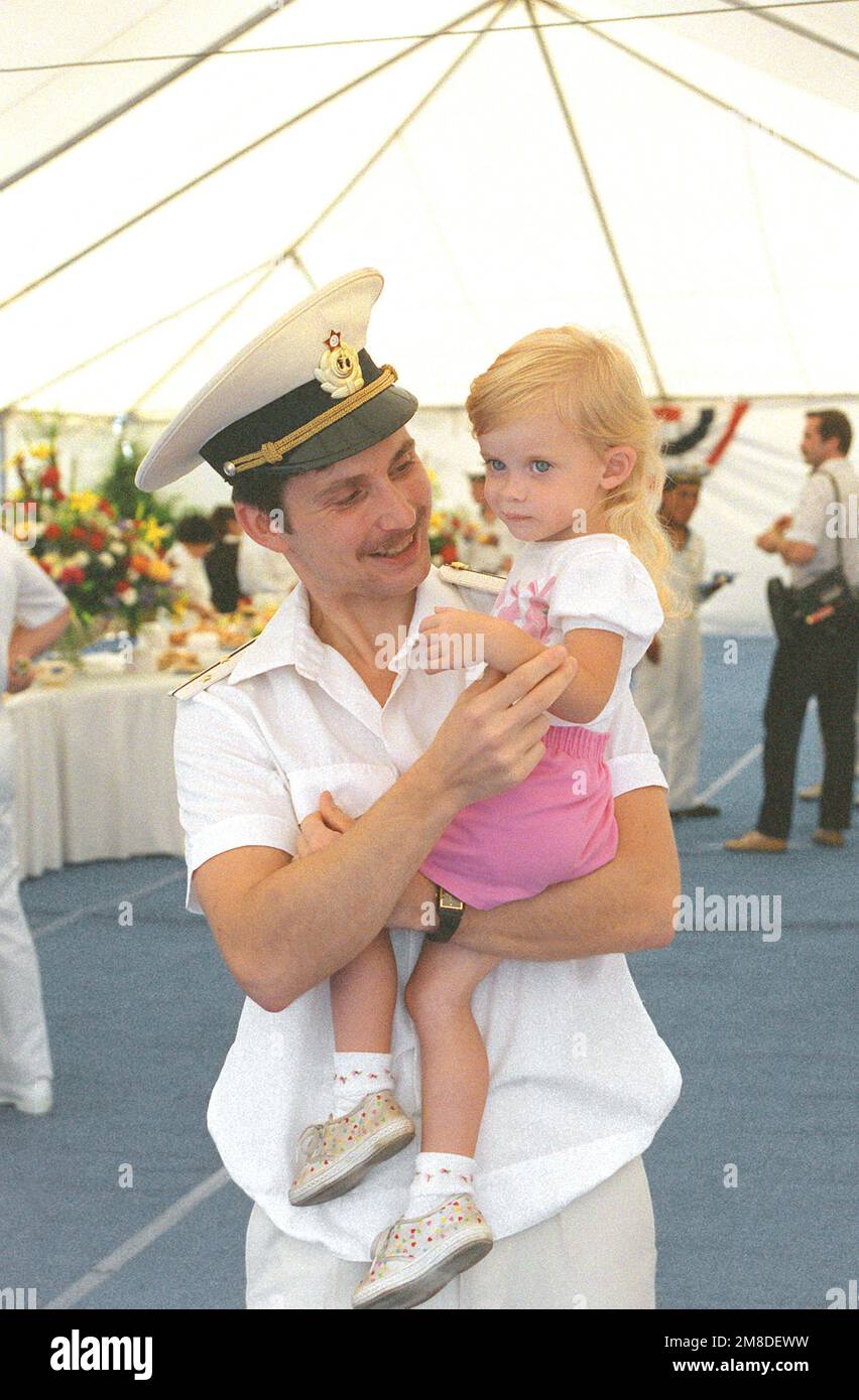 A Soviet navy senior lieutenant holds an American officer's child ...