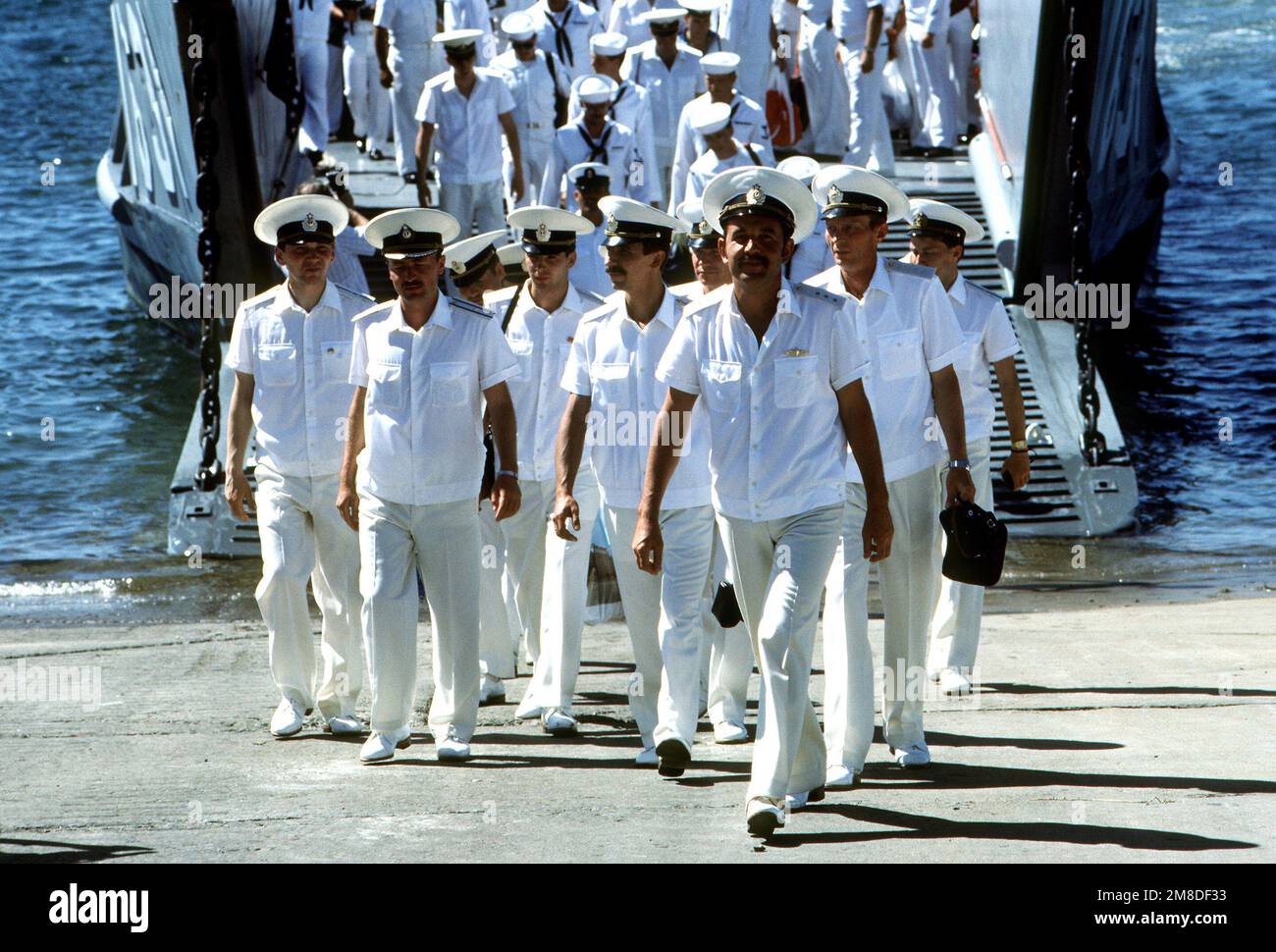 Soviet officers lead the way up a boat ramp after arriving with a group ...
