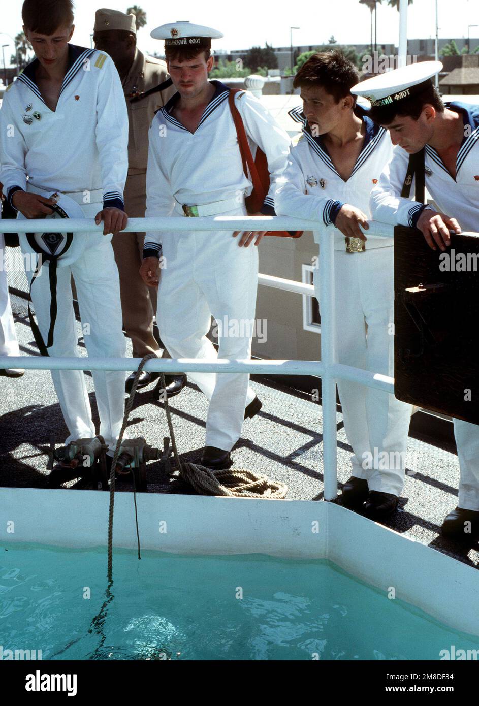 Soviet sailors watch as a diver ascends from a training tank during ...