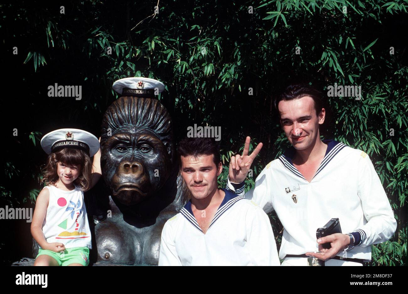 Two Soviet sailors pose with an American child during their tour of the ...