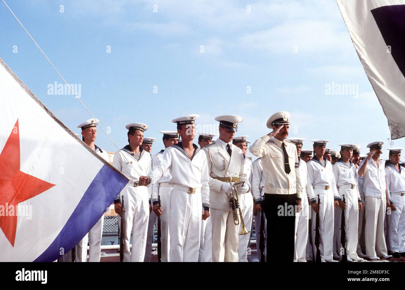 A Soviet sailor stands in front of the ranks as he holds the corner of ...