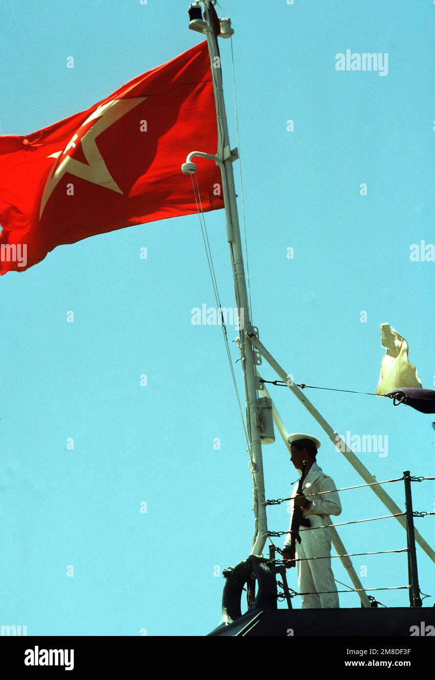 A Soviet sailor stands watch beneath the jack flying on the bow of one ...