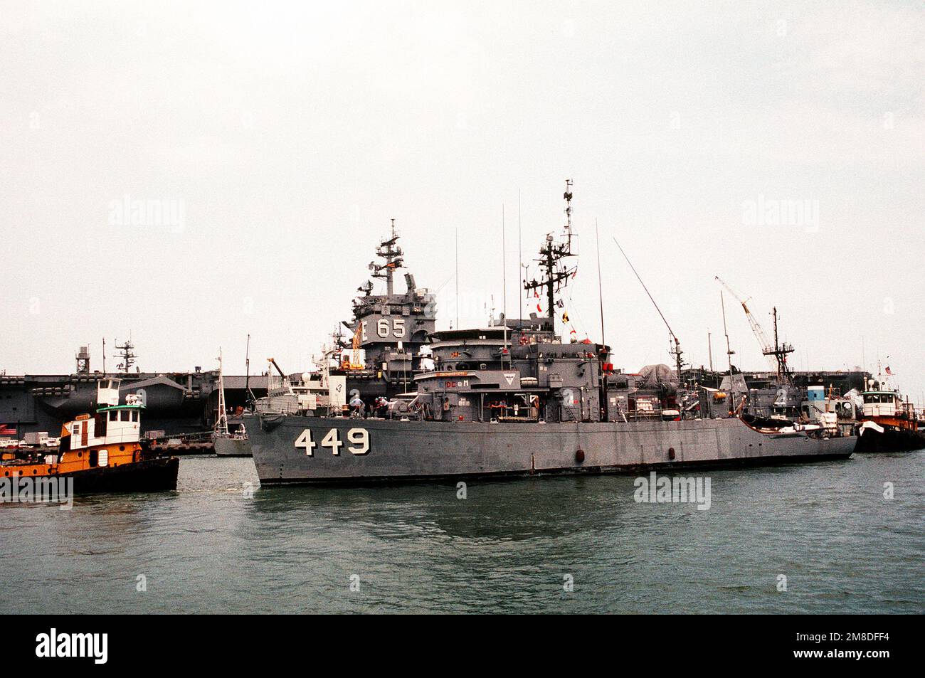 Harbor tugs maneuver the ocean minesweeper USS IMPERVIOUS (MSO-449) as ...