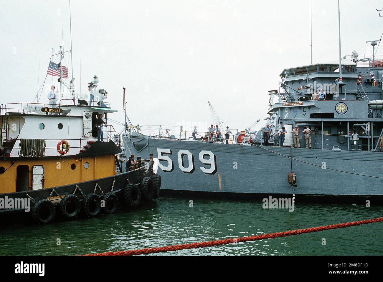 A commercial harbor tug maneuvers the ocean minesweeper USS ADROIT (MSO ...