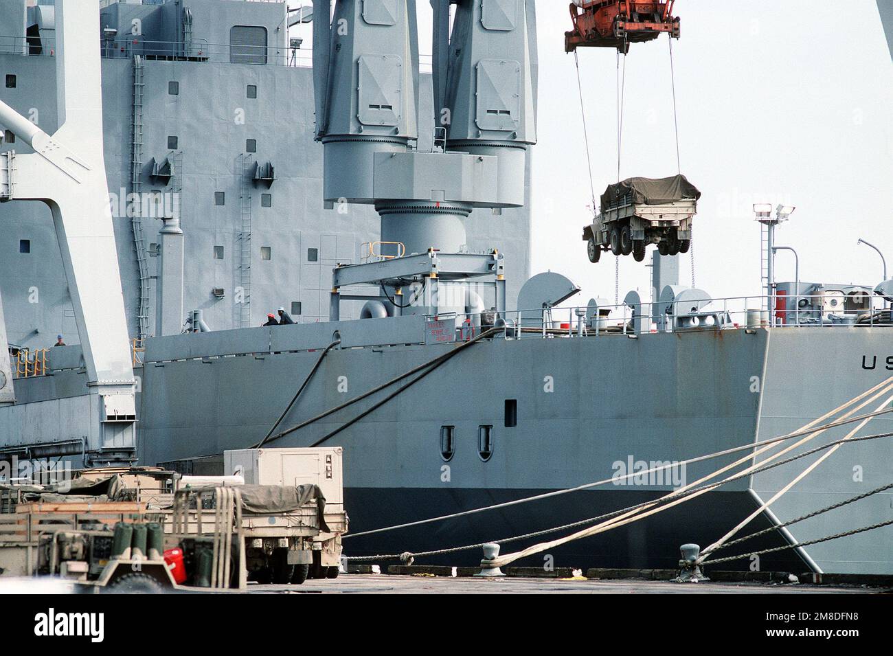 A crane lowers an M-35A2 2-1/2 ton cargo truck aboard a rapid-response ...