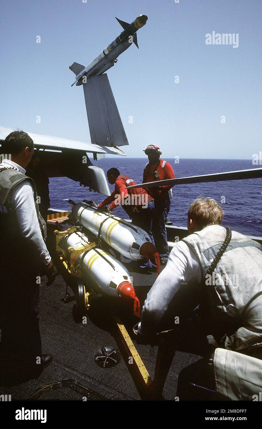 Flight deck crewmen push a skid containing two Mark 20 Rockeye II ...