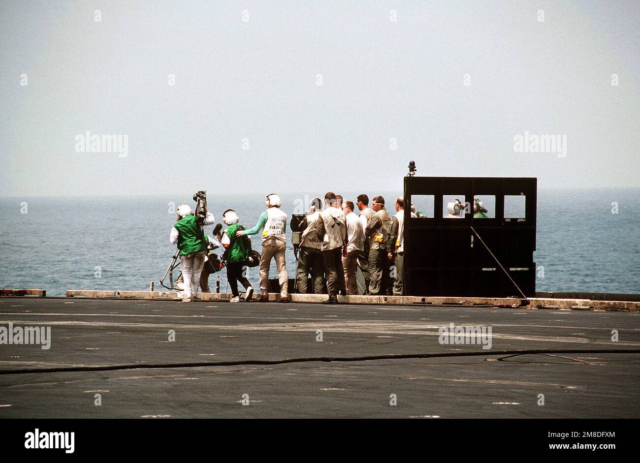 A television camera crew hurries onto the catwalk beside the landing ...