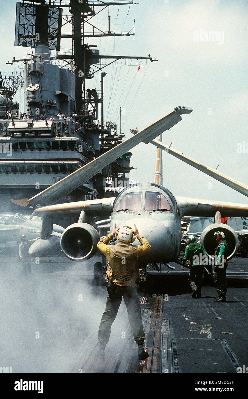 A plane director guides an Air Anti-submarine Squadron 37 (VS-37) S-3A ...