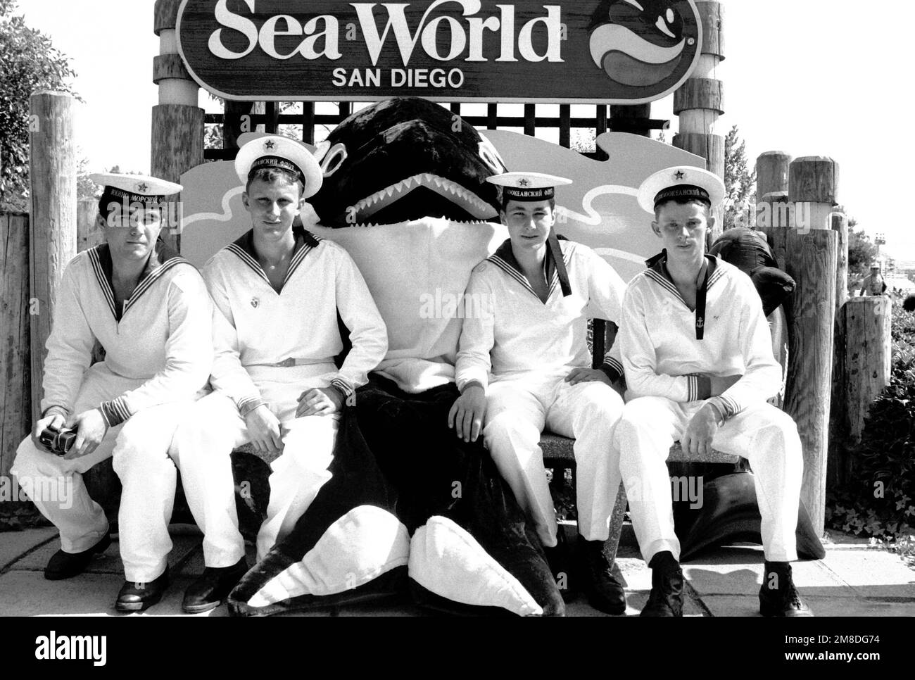 Four Soviet sailors sit in front of a sign at Sea World during a five ...